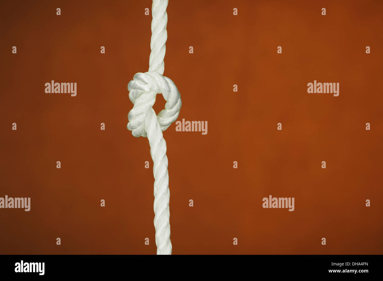 A Rope Tied In A Knot Against A Brown Background Stock Photo - Alamy