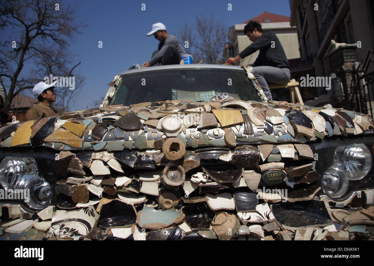 Landrover decorated with pottery and porcelain Workers decorate a Land ...