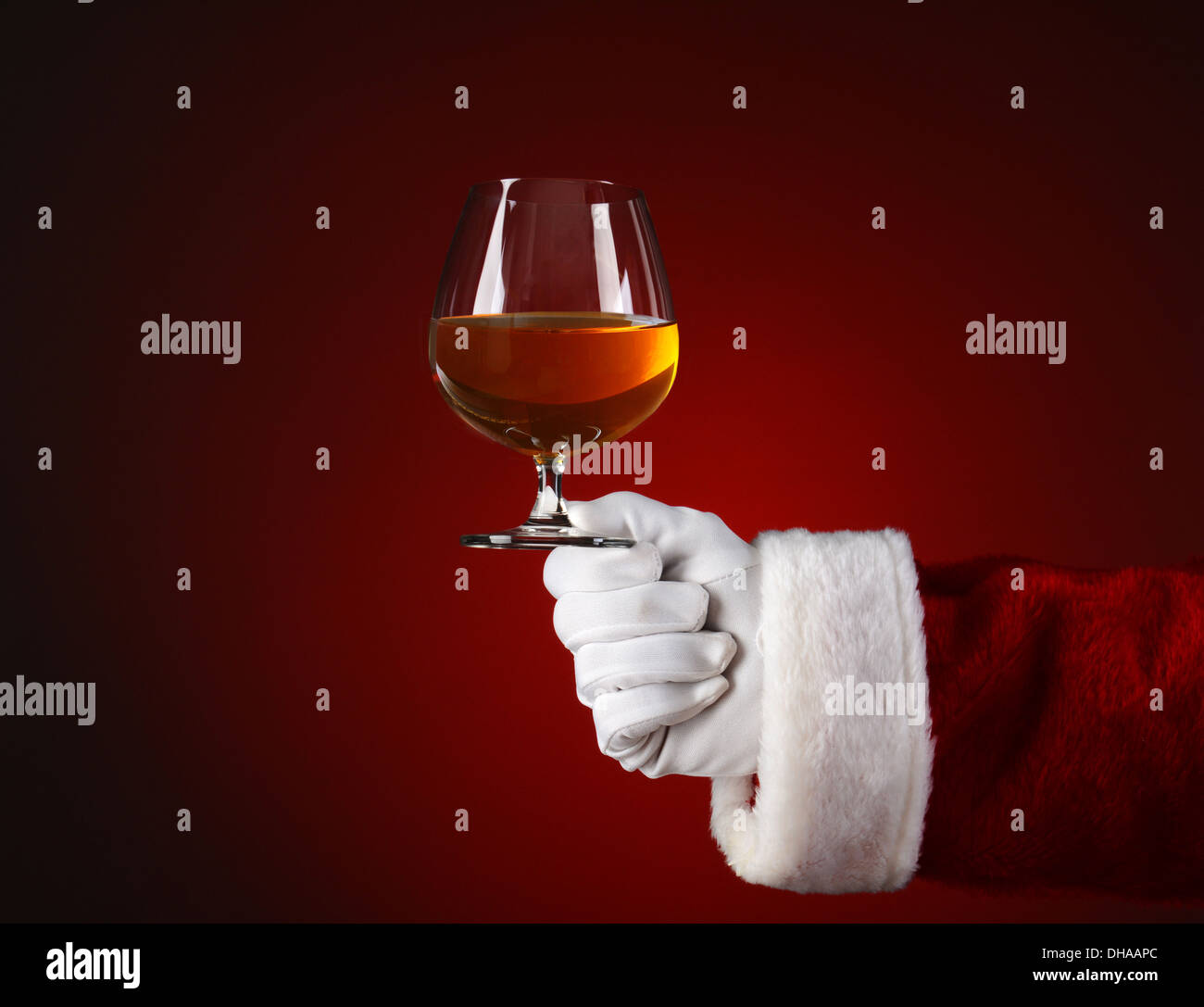 Closeup of Santa Claus holding a brandy snifter. Horizontal format on a ...