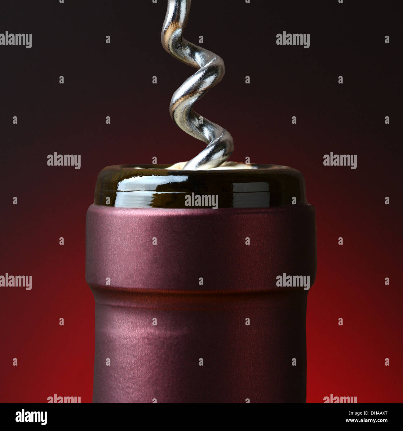 Closeup of the neck of a wine bottle with a corkscrew partially in the ...