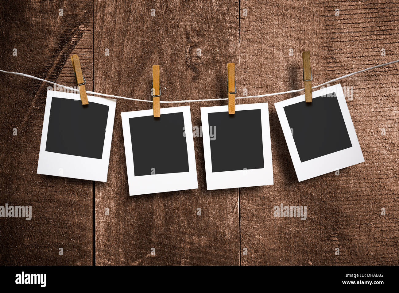 four photo paper attach to rope with clothes pins on wooden background ...