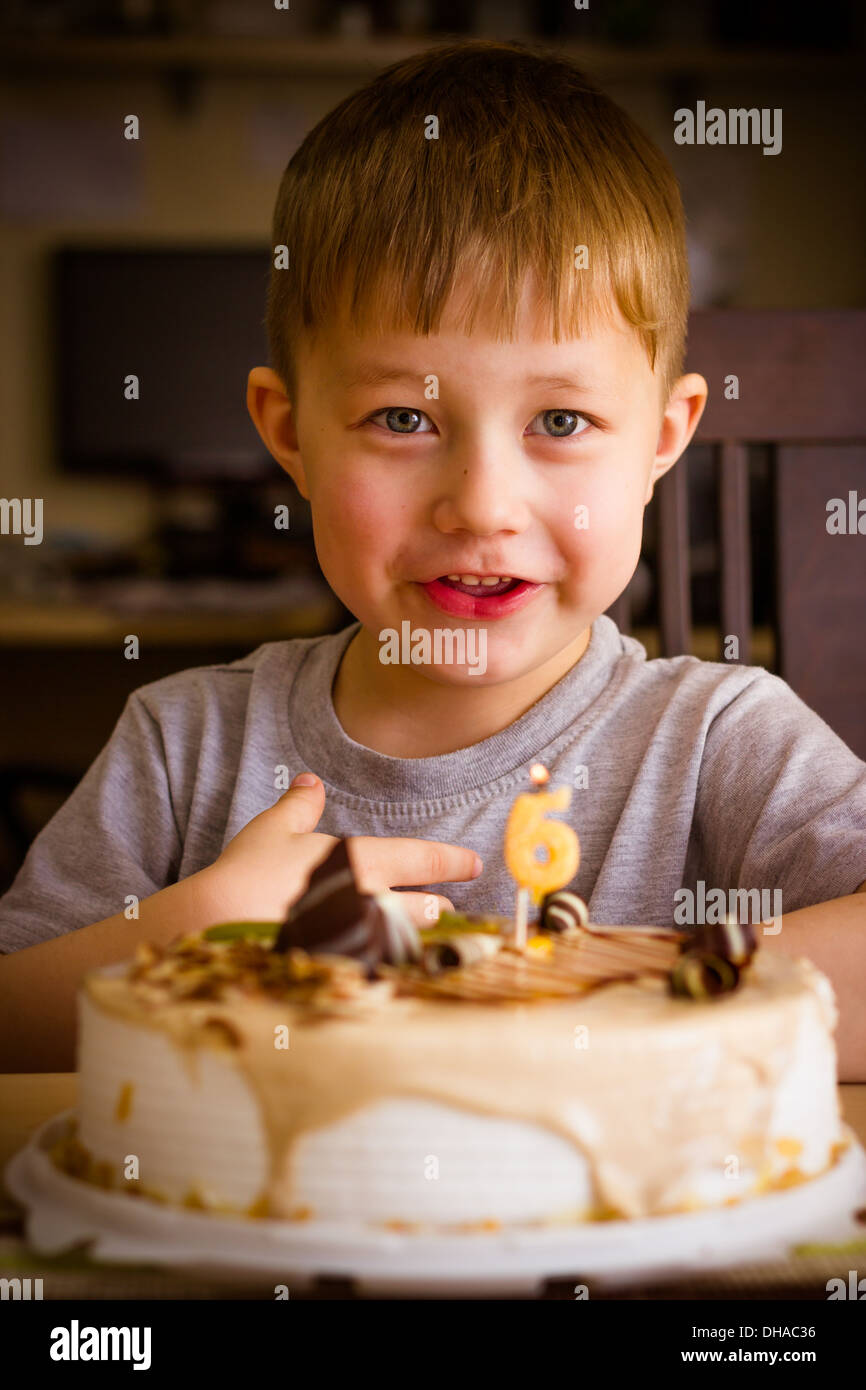 The boy looks at the birthday cake Stock Photo - Alamy