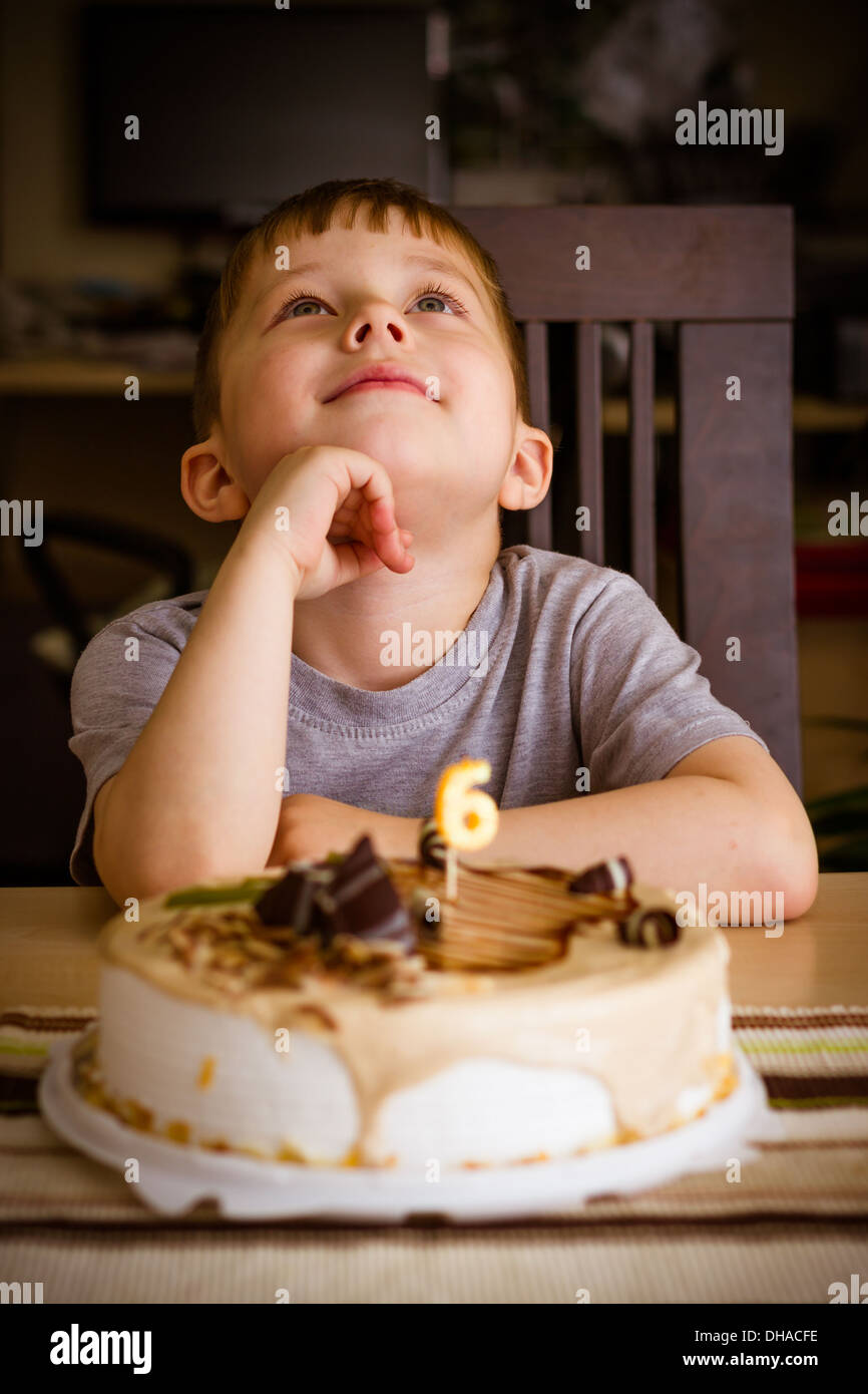The boy looks at the birthday cake Stock Photo - Alamy