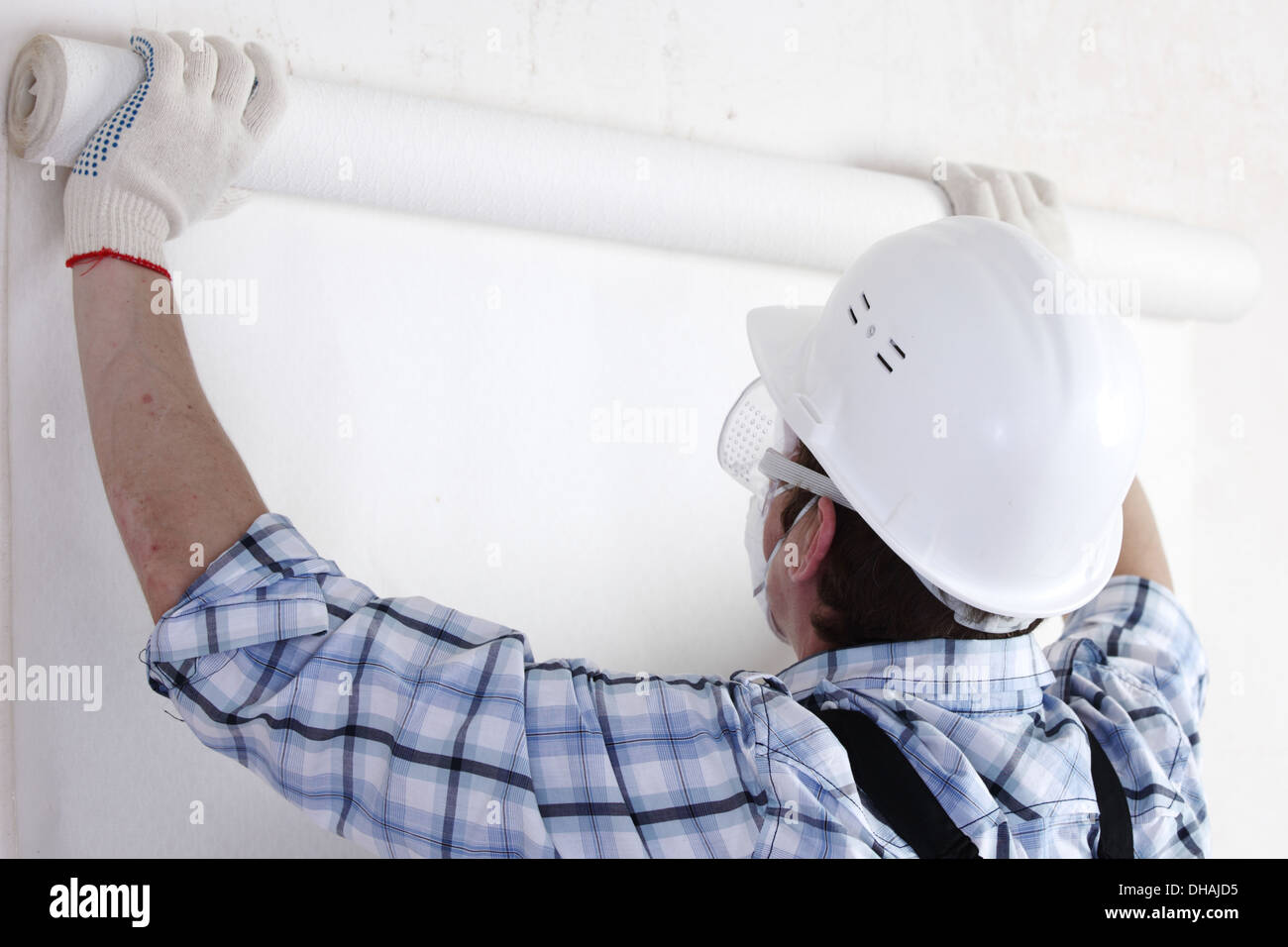 worker attaching wallpaper to wall Stock Photo - Alamy