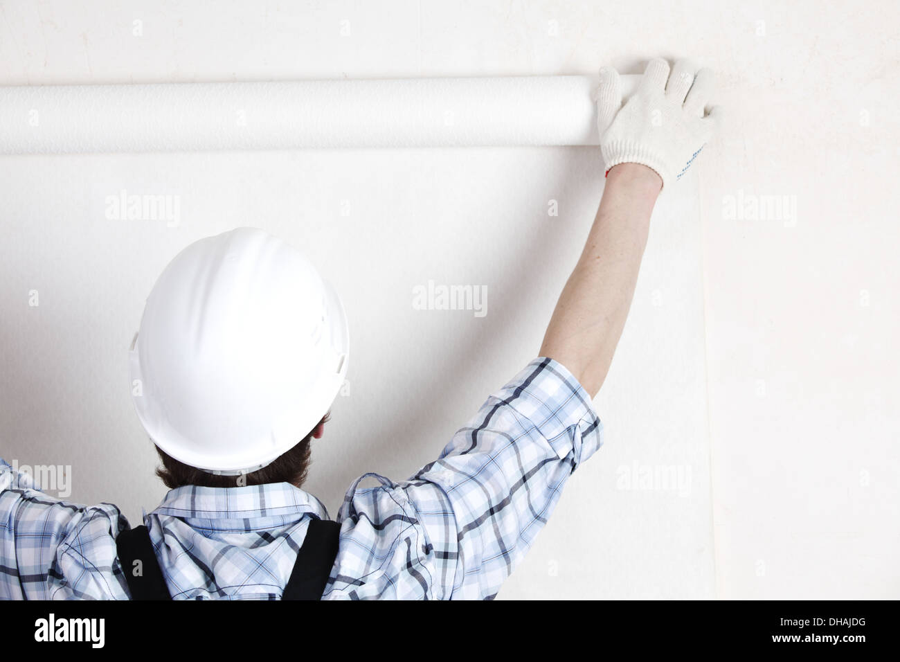worker attaching wallpaper to wall Stock Photo - Alamy