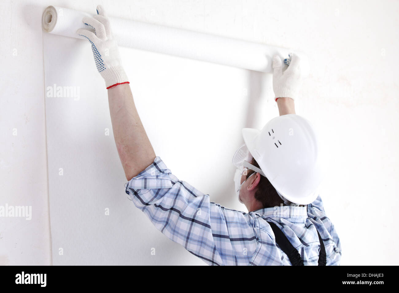 worker attaching wallpaper to wall Stock Photo - Alamy