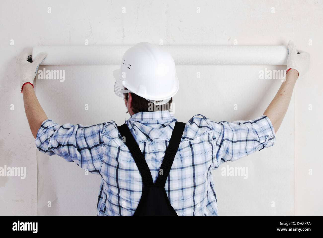 worker attaching wallpaper to wall Stock Photo - Alamy