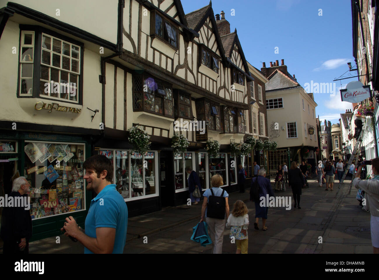 People walking down a street with shops on either side Stock Photo - Alamy