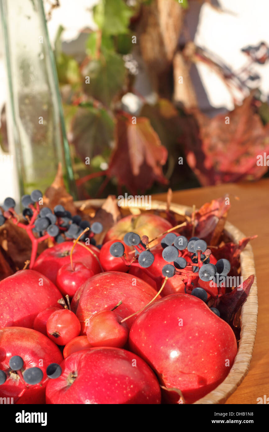 Red apples, bottle and berry in a basket on table Stock Photo - Alamy