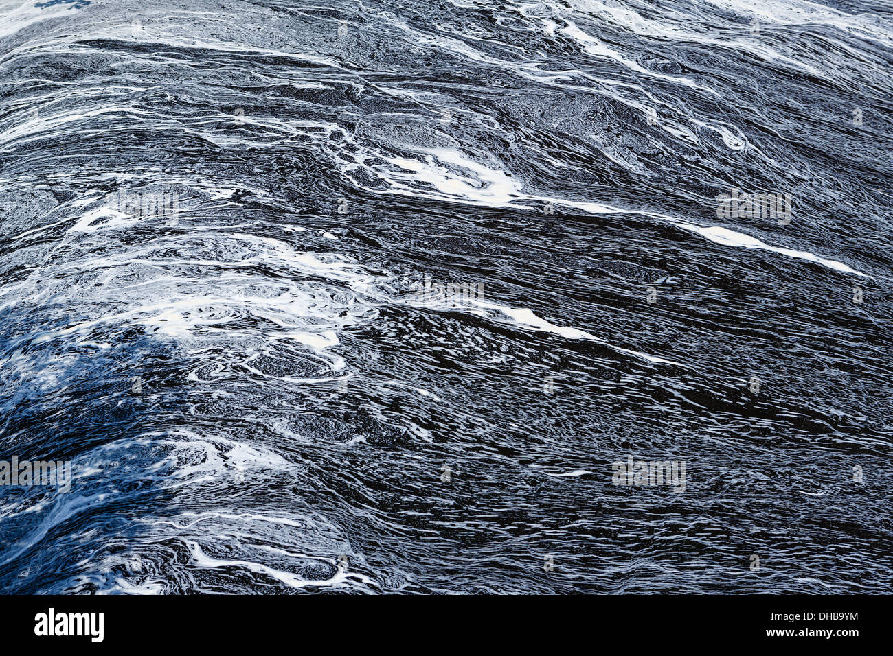 Pattern on water formed by foam and algas Stock Photo - Alamy