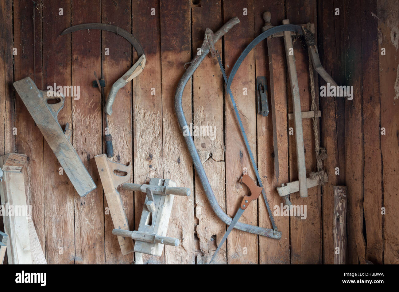a selection of old tools and saws on an old workshop wall in Finland ...