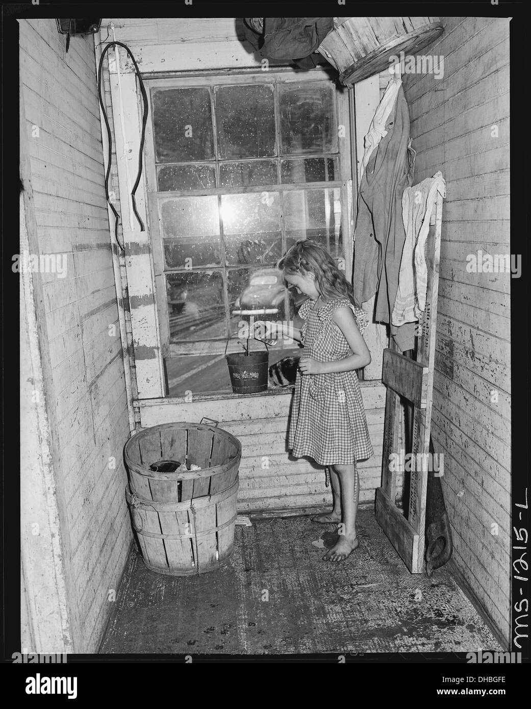 Betty, the daughter of J.F. Bryant, a miner, is seen watering a flower ...