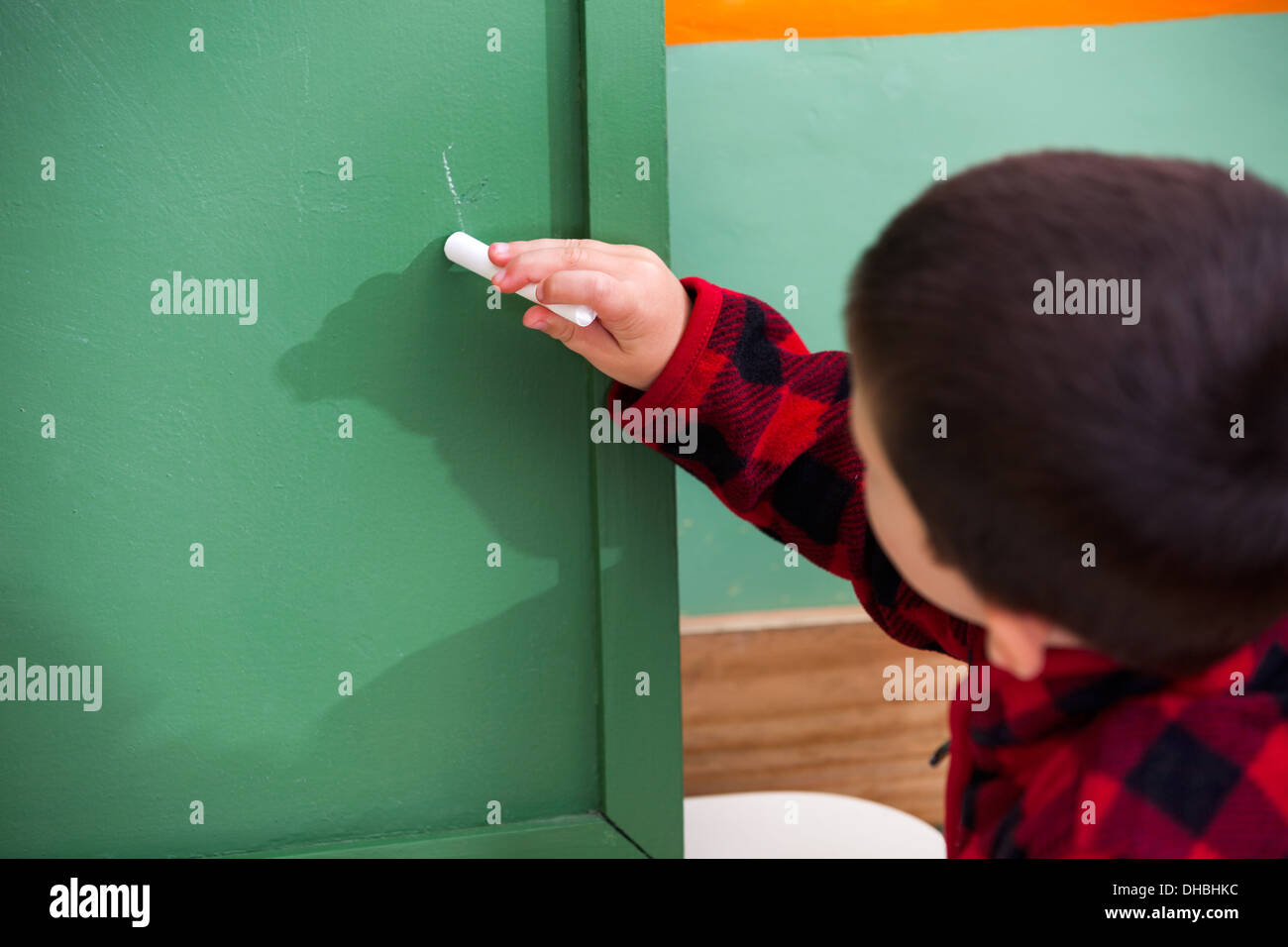 Boy Writing On Green Chalkboard In Preschool Stock Photo - Alamy