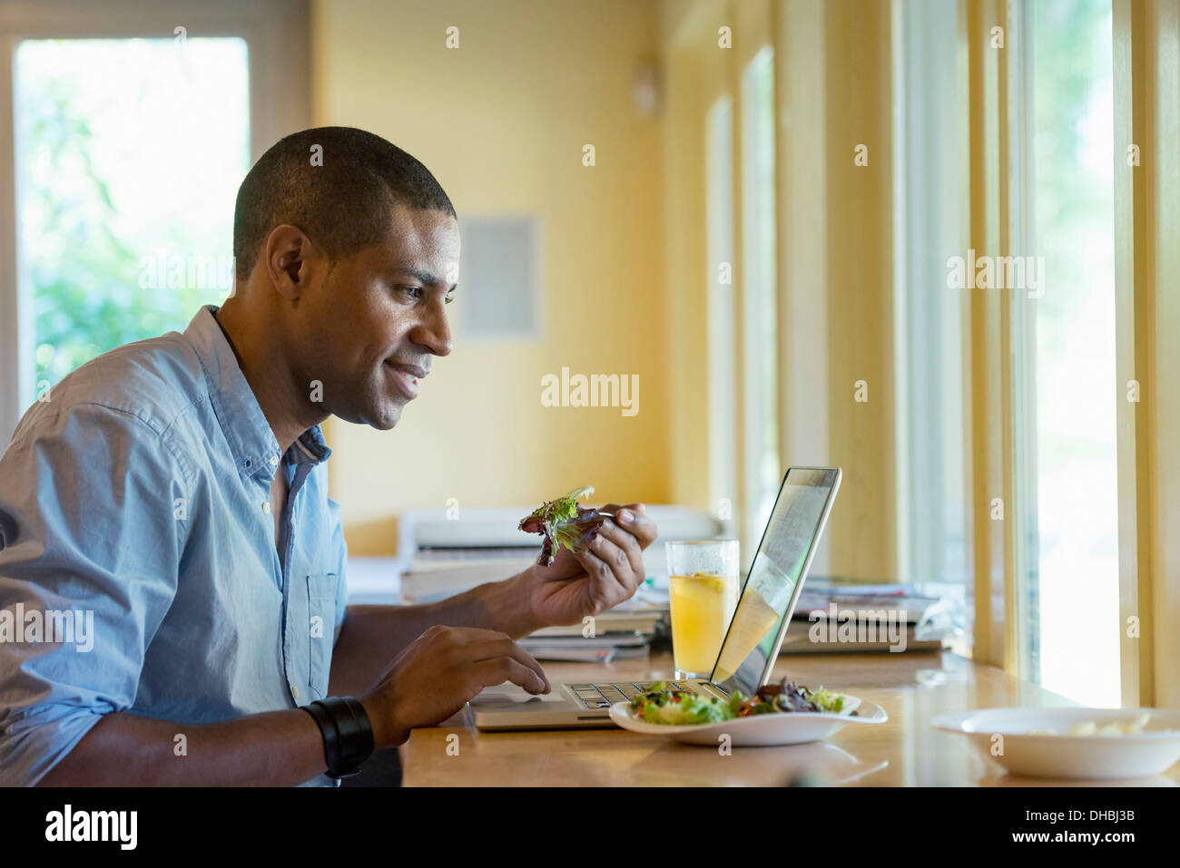 A person sitting alone in a cafe. A man working on a laptop Stock Photo ...