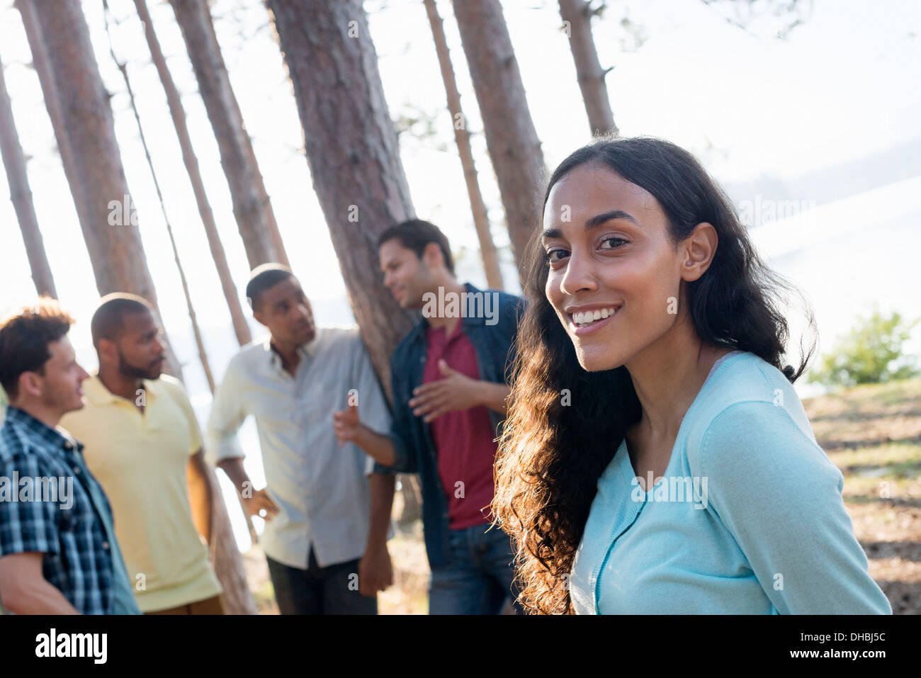 Lakeside. A friends gathered in the shade of pine trees in summer Stock ...