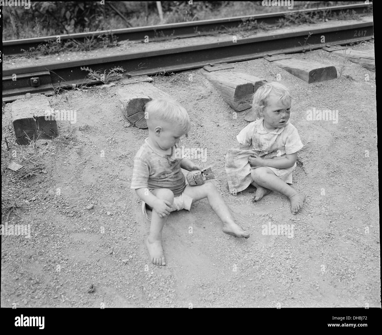 This image shows children playing near railroad tracks outside their ...