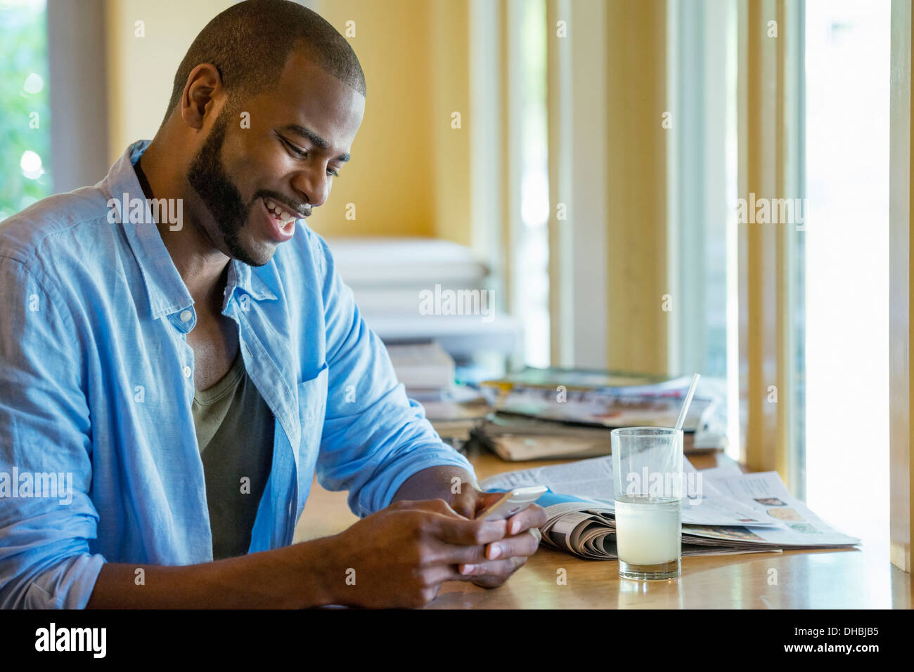 A man sitting alone in a cafe, using his smart phone Stock Photo - Alamy