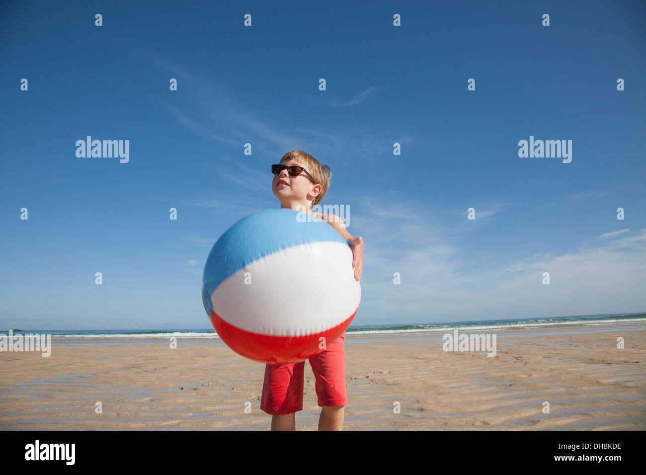 A boy on the beach holding a large inflatable beach ball Stock Photo ...