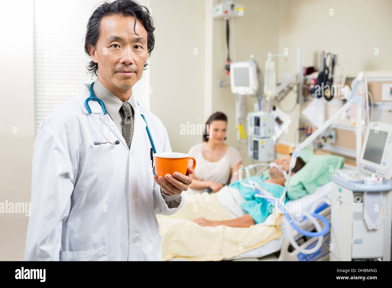 Doctor Holding Coffee Cup With Patient Resting In Hospital Stock Photo ...