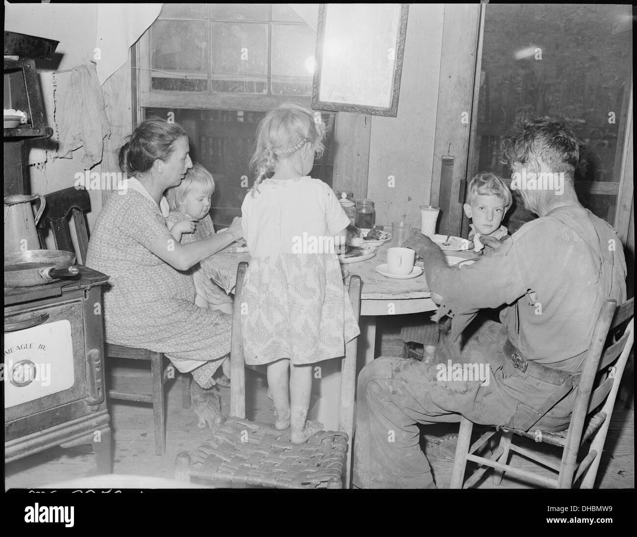 Dillard Eldridge and his family are shown at supper in their four-room ...