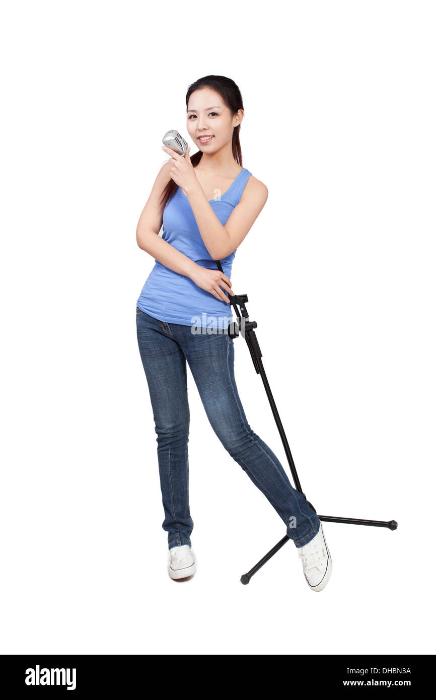 Studio portrait of young woman singing into microphone Stock Photo - Alamy