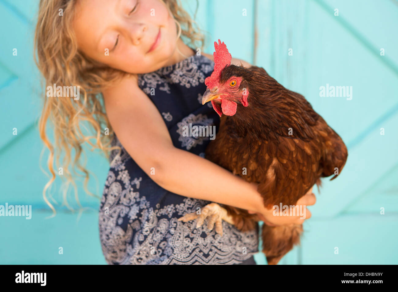 A young girl holding a chicken in her arms Stock Photo - Alamy