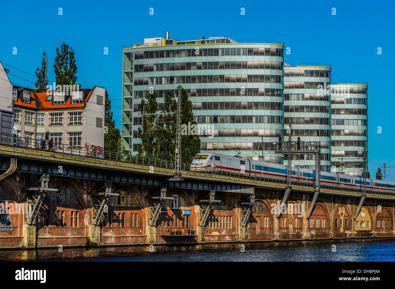 High speed train traveling along Spree River with modern office ...
