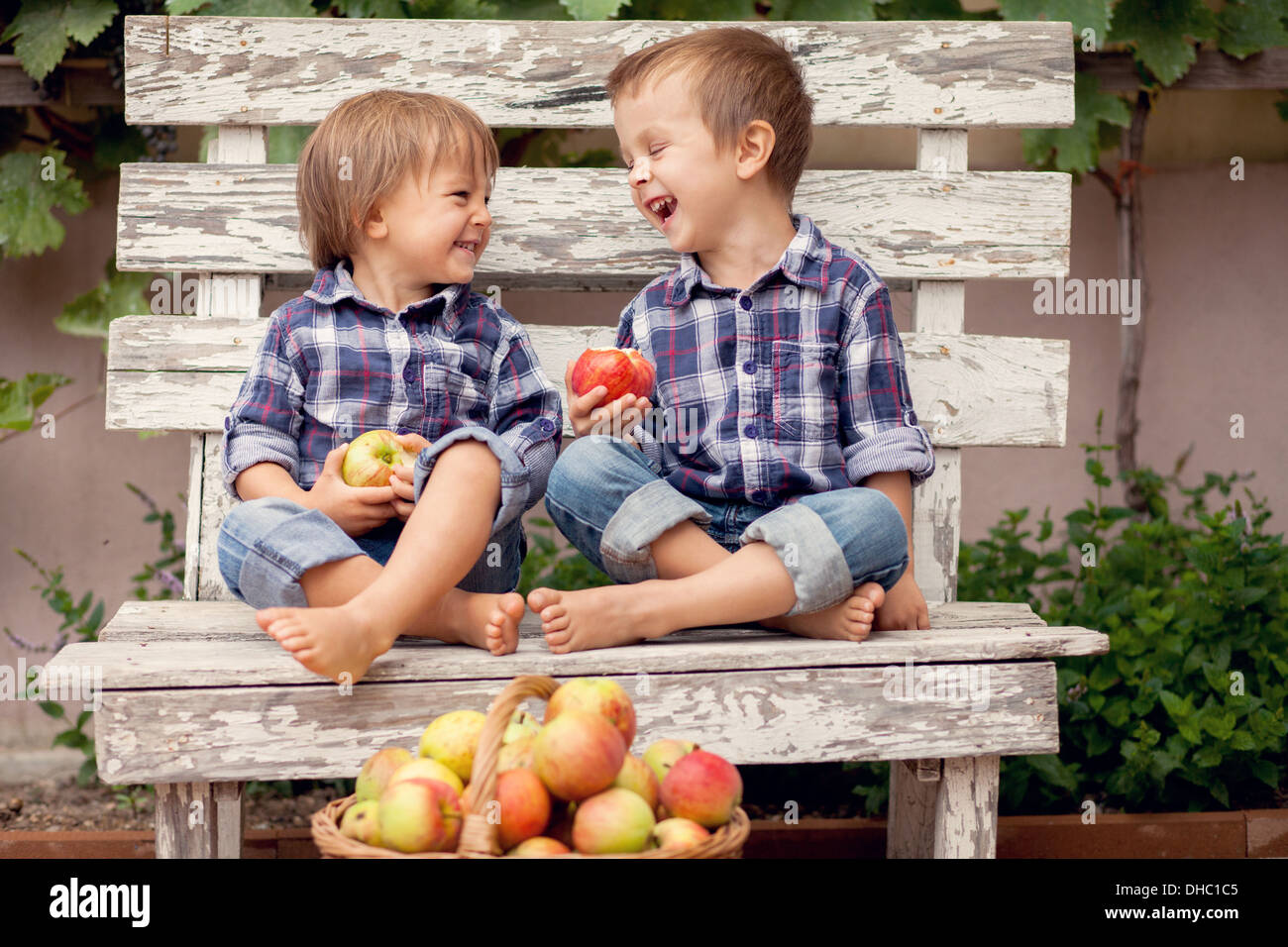 Two boys with a basket of apples, sitting on a bench Stock Photo - Alamy