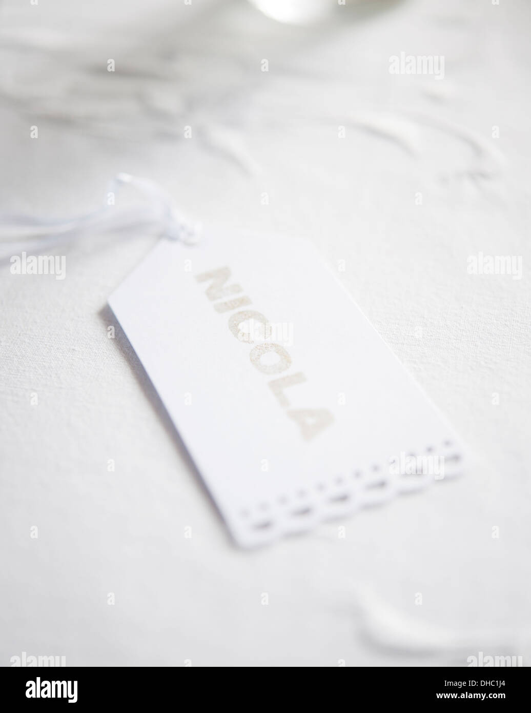 A name tag on a white wedding breakfast table Stock Photo - Alamy