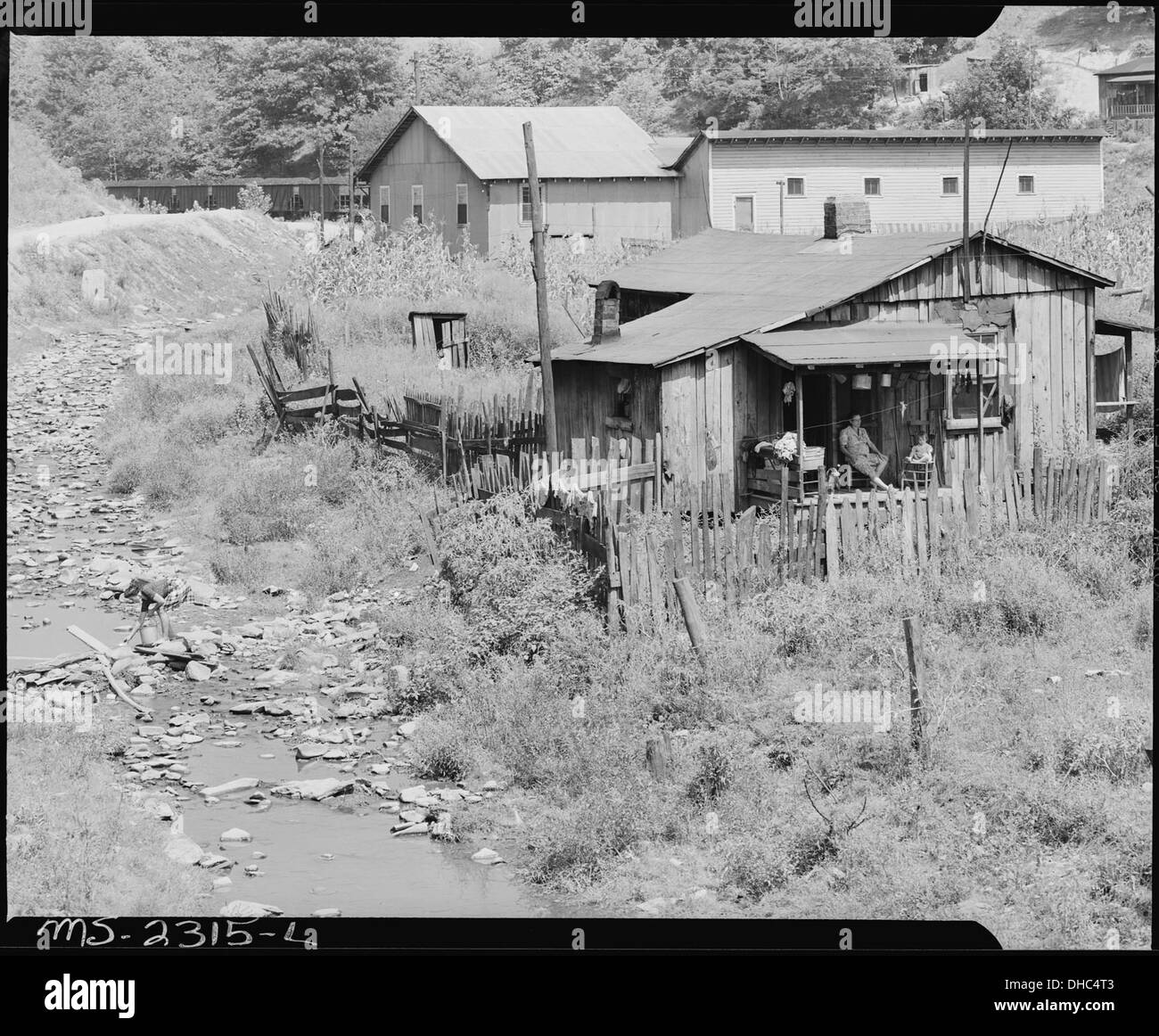 This photograph shows miner houses with a stream and store in the ...