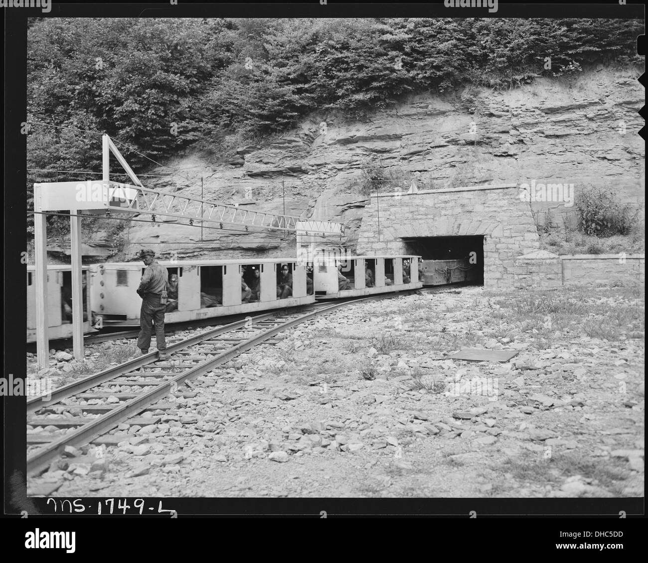 This photograph shows a group of workers heading into a mine on a 'man ...
