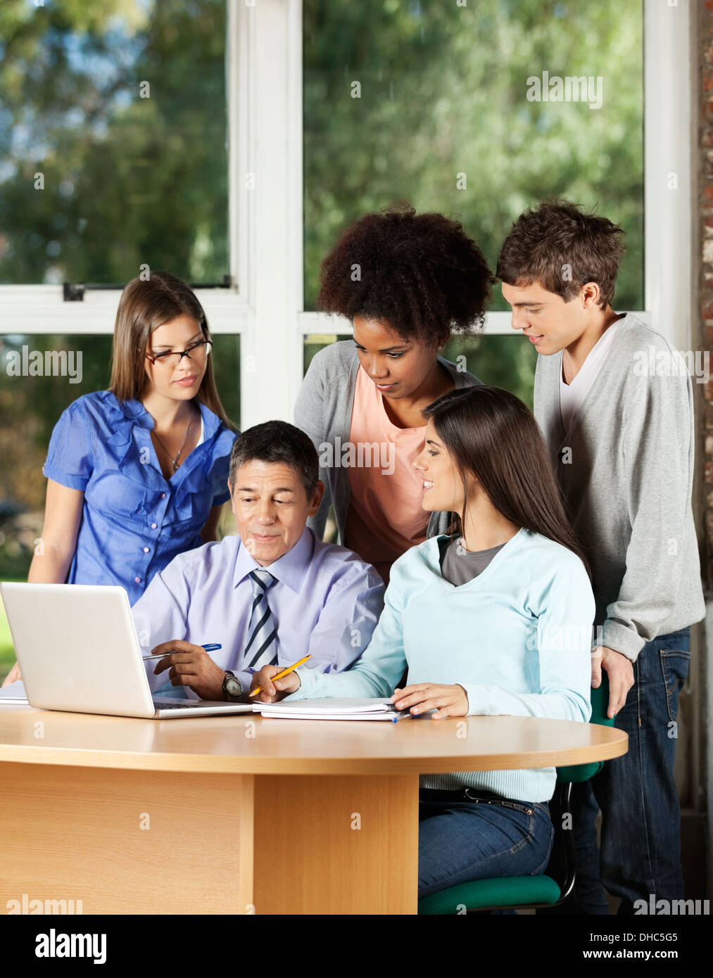 Professor With Laptop Explaining Students In Classroom Stock Photo - Alamy