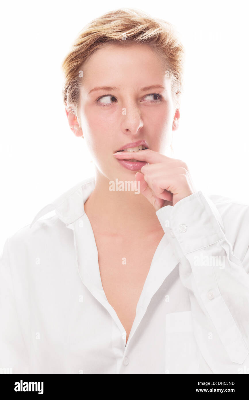young cute woman bites in her finger looking to side on white ...