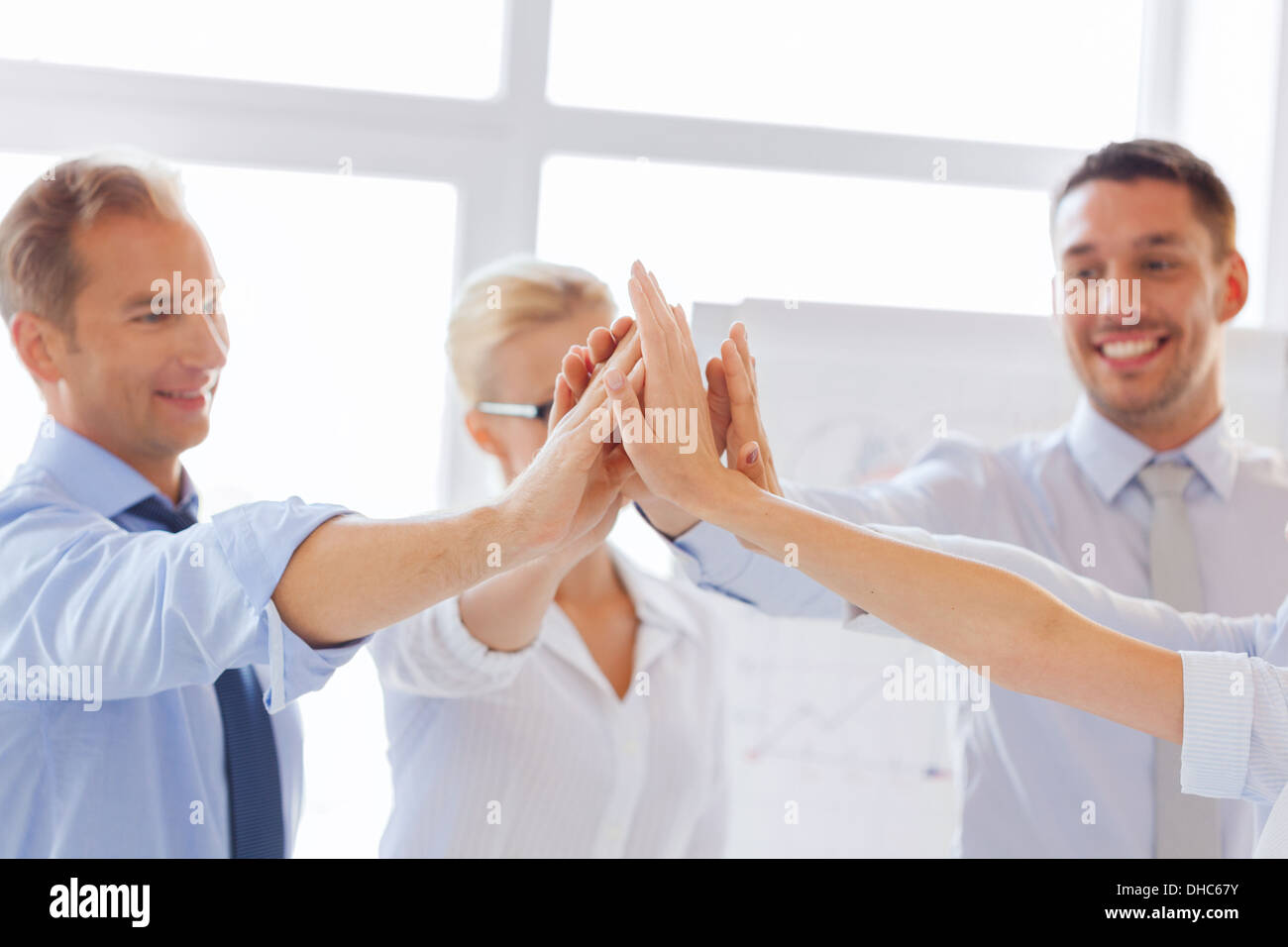 happy business team giving high five in office Stock Photo - Alamy