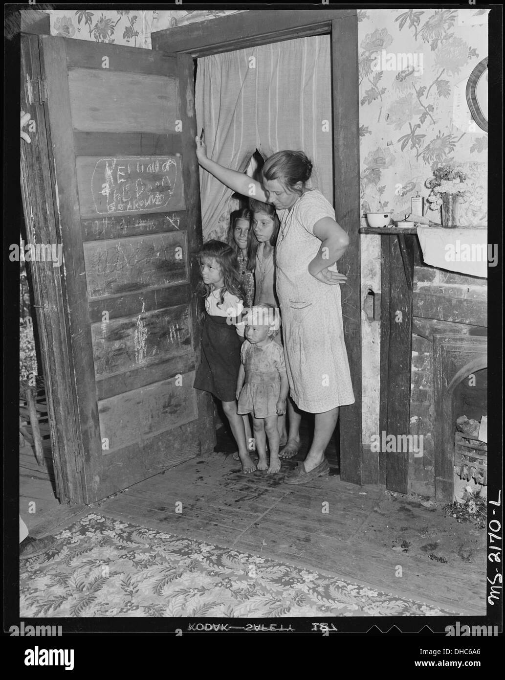 Mrs. Ceph Holland, the wife of a miner, stands in the doorway with four ...