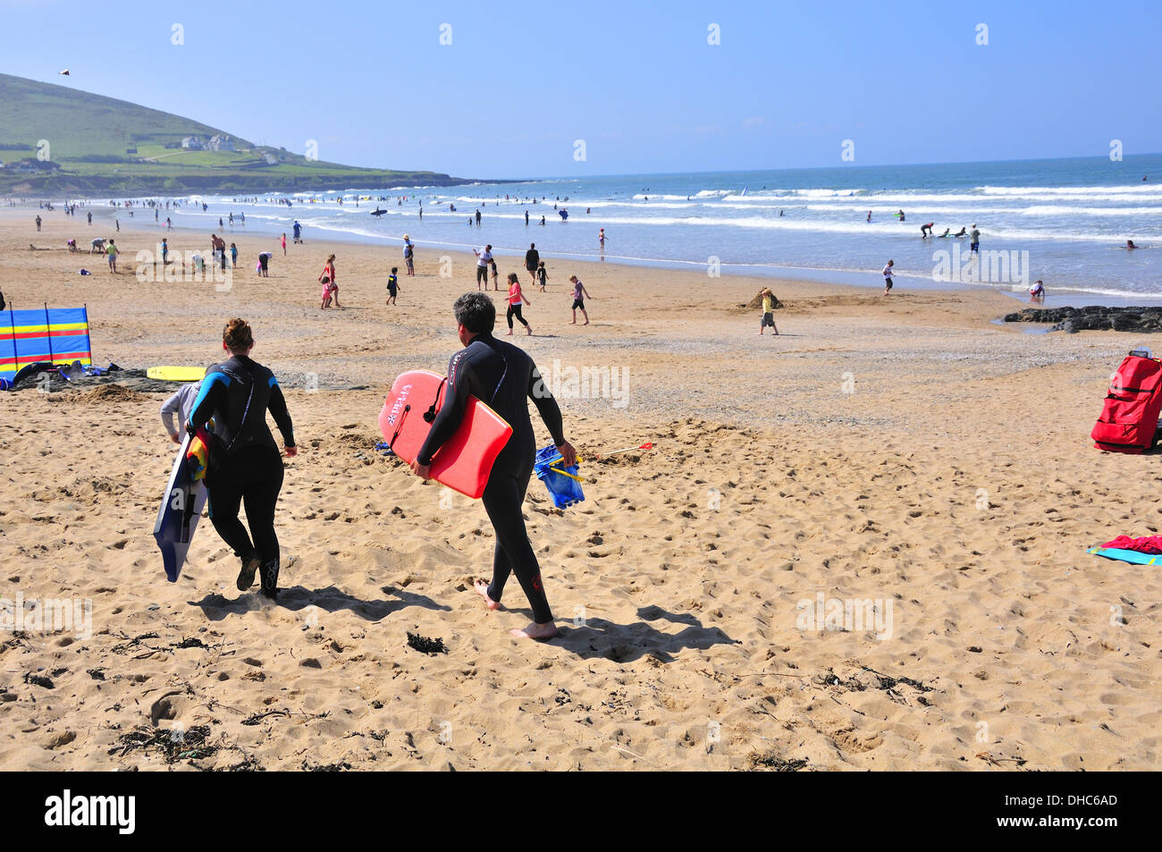 Surfers and holidaymakers on the beautiful golden sand surfing beach at ...
