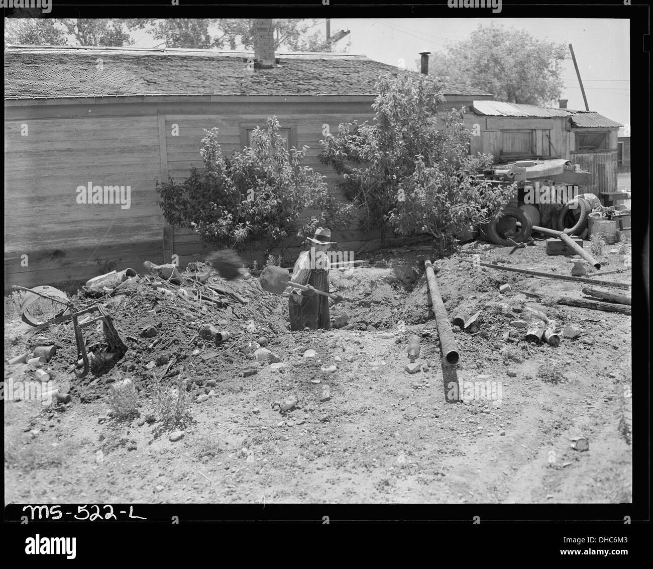Manuel Alcala, a miner, digs a cesspool that he is installing at his ...