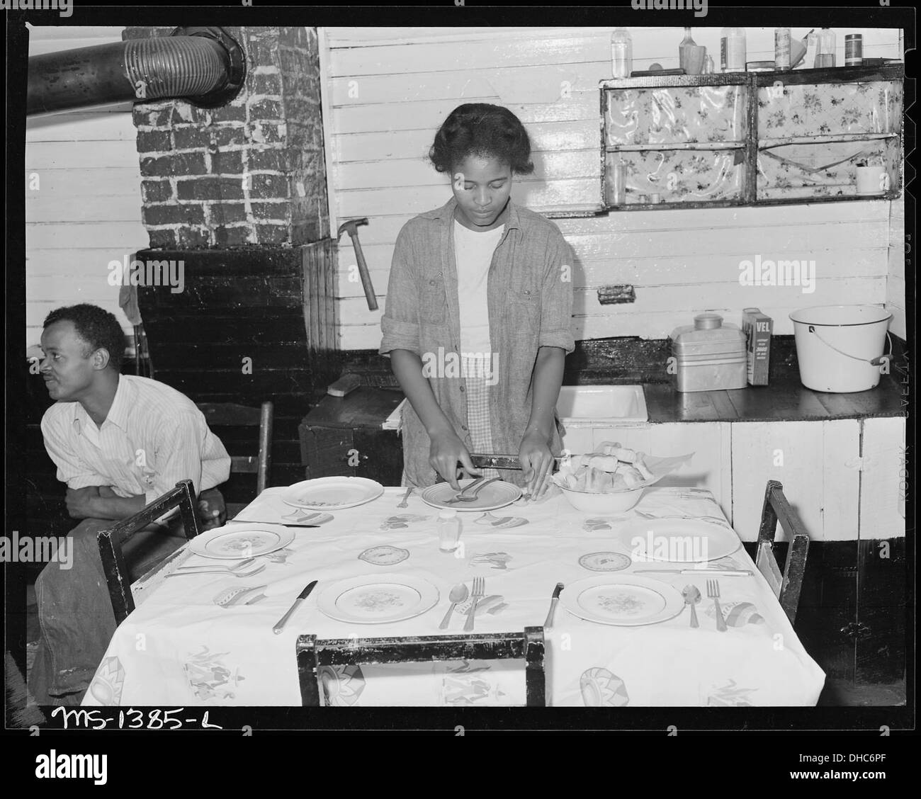 Mrs. James Robert Howard prepares supper in their home, while her ...