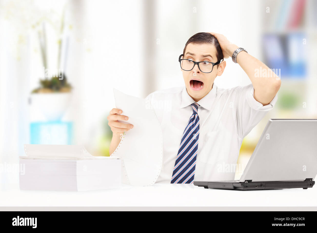 Shocked young accountant looking at very expensive bill Stock Photo - Alamy