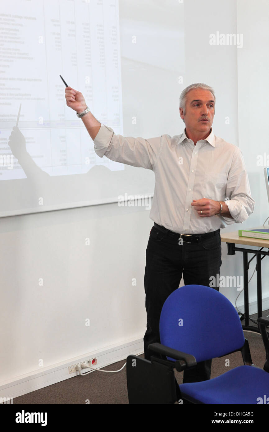 Teacher pointing at white board Stock Photo - Alamy