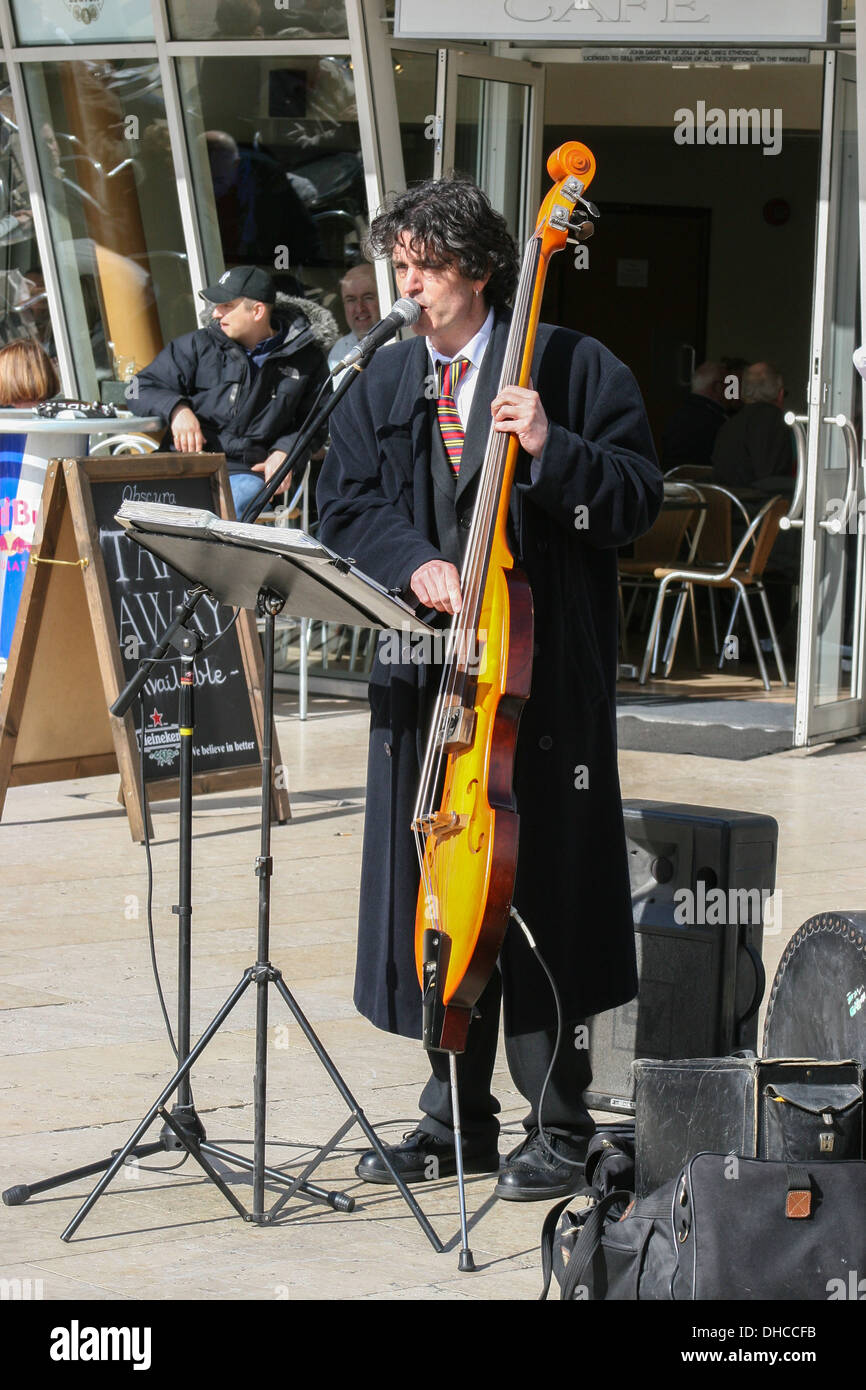 Busker playing double bass and singing in Bournemouth town center ...