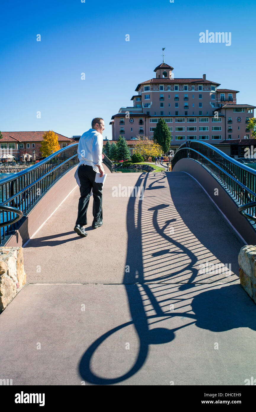 Man cross a bridge over Cheyenne Lake, The Broadmoor, historic luxury ...