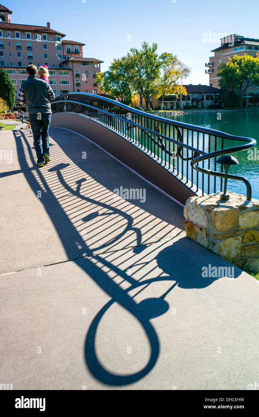 Tourists cross a bridge over Cheyenne Lake, The Broadmoor, historic ...