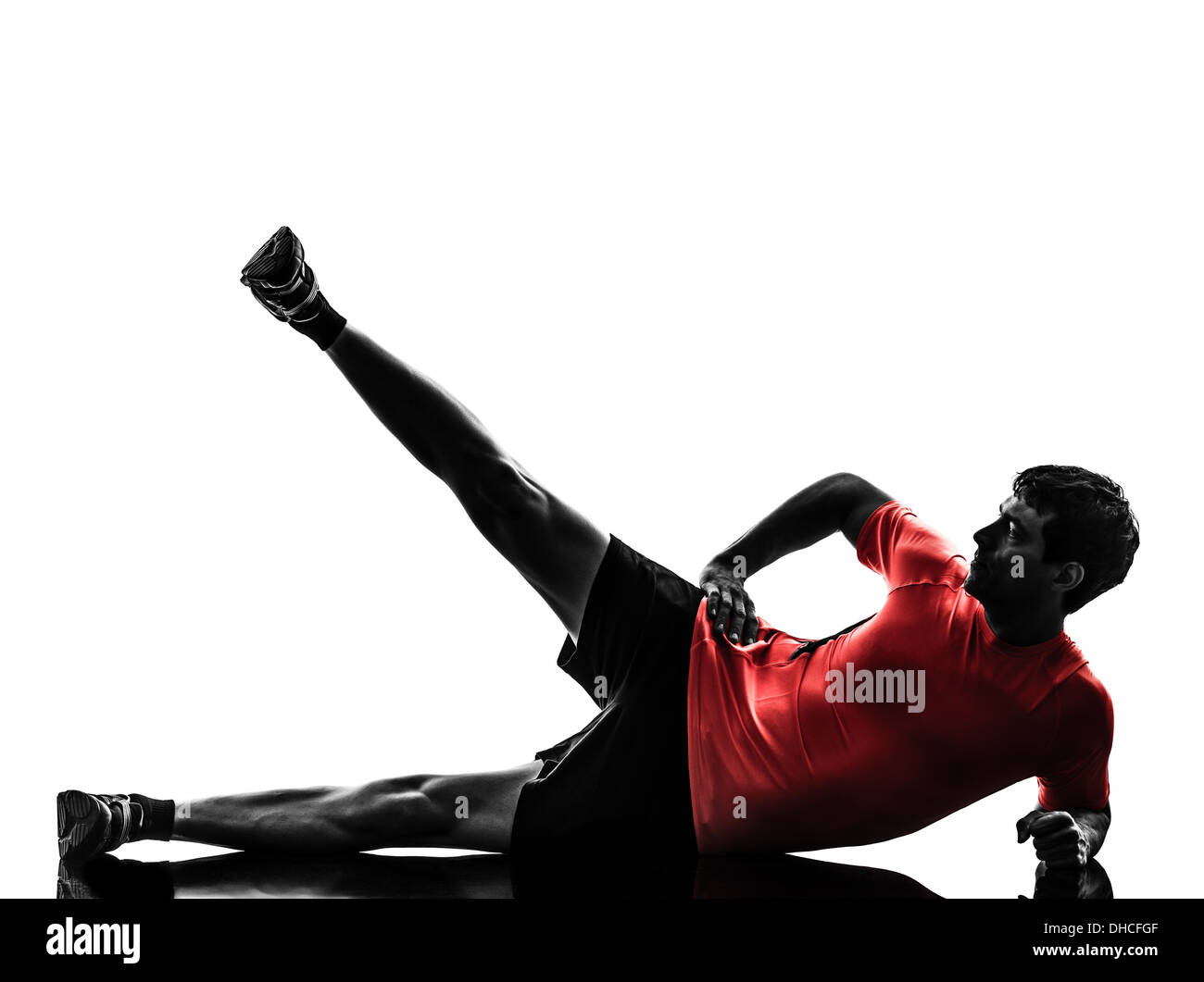 one man exercising fitness workout legs in the air lying on side in ...