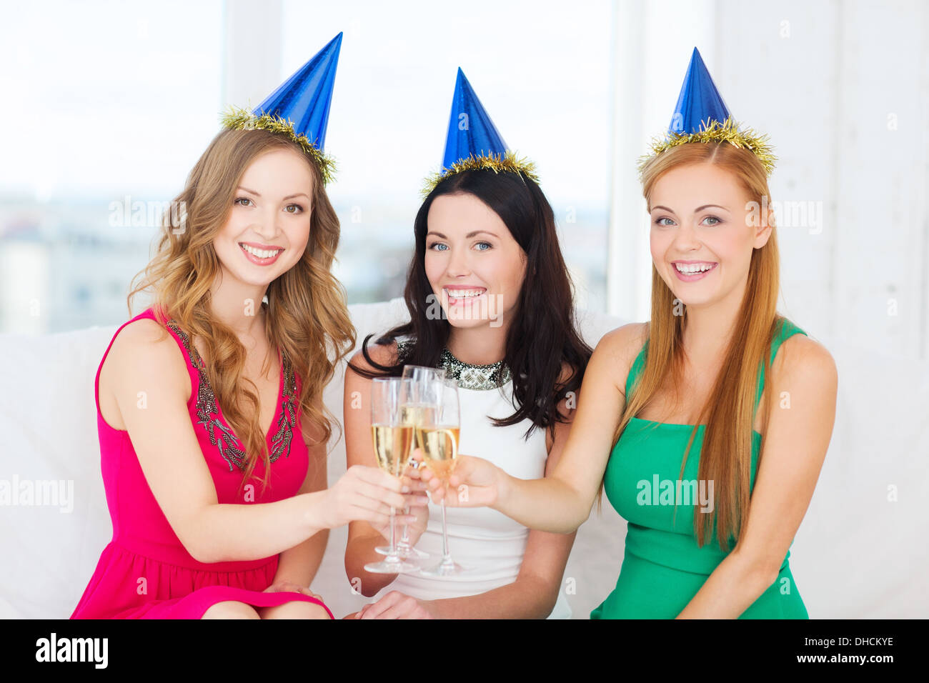three women wearing hats with champagne glasses Stock Photo - Alamy