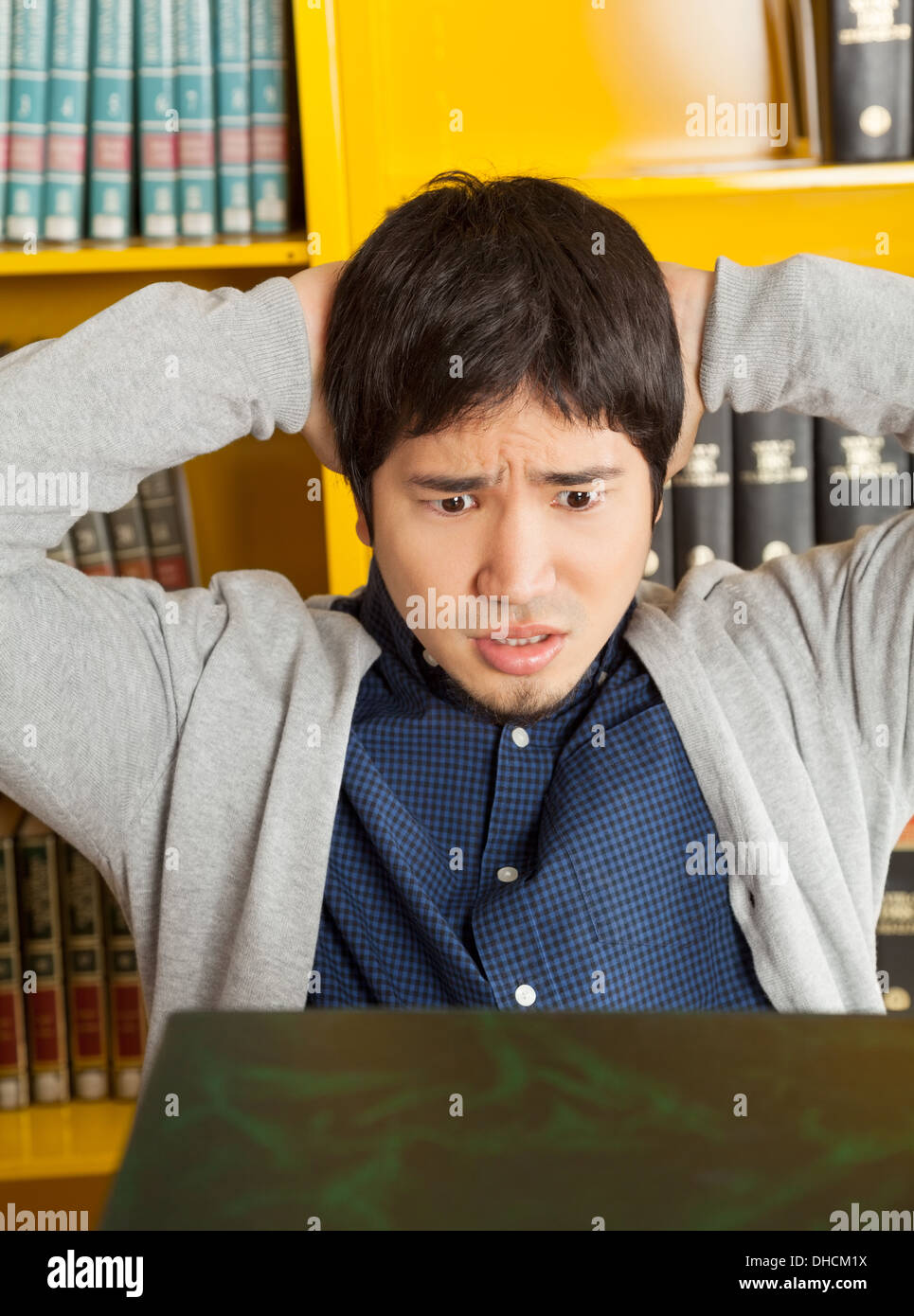 Student With Hands Behind Head Looking At Books In Library Stock Photo ...