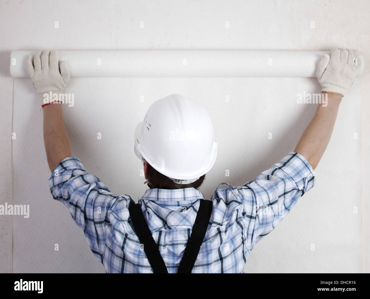 worker attaching wallpaper to wall Stock Photo - Alamy