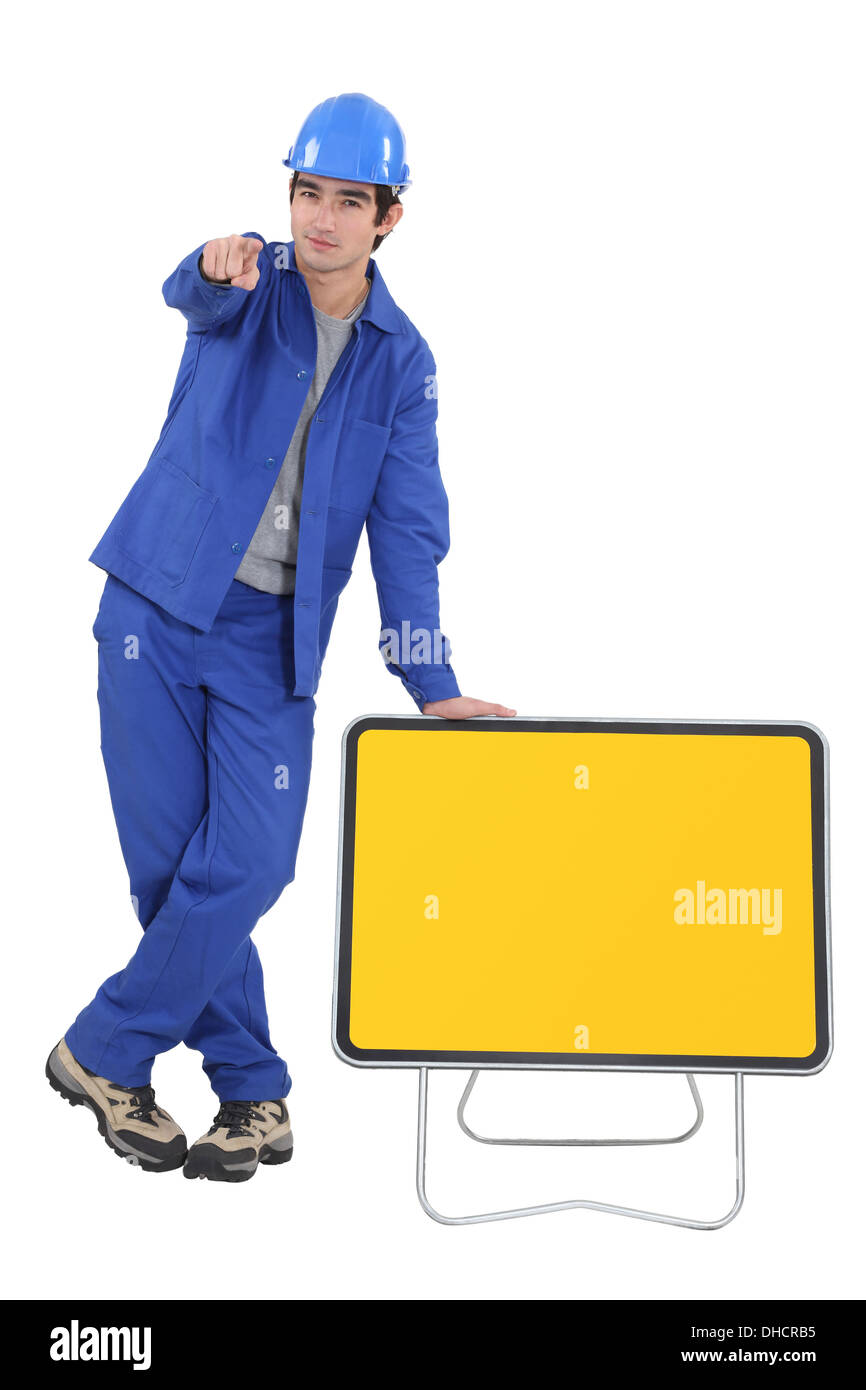 Construction worker with yellow road sign Stock Photo - Alamy