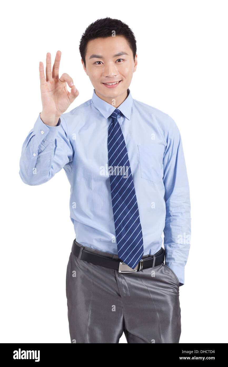 Portrait of young businessman making OK sign in white background Stock ...