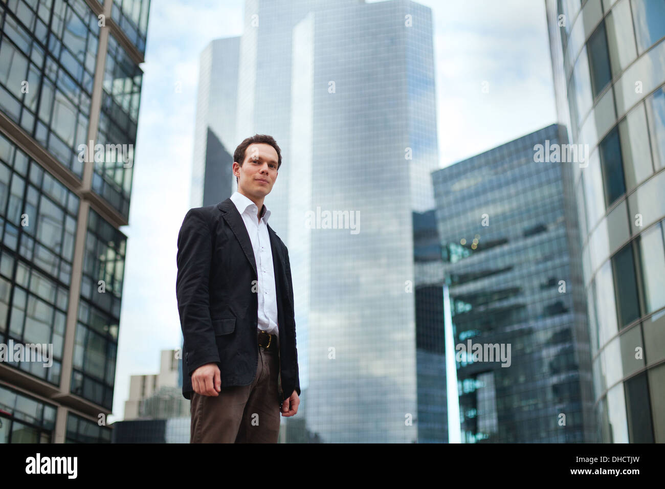 young business man on the office buildings background Stock Photo - Alamy